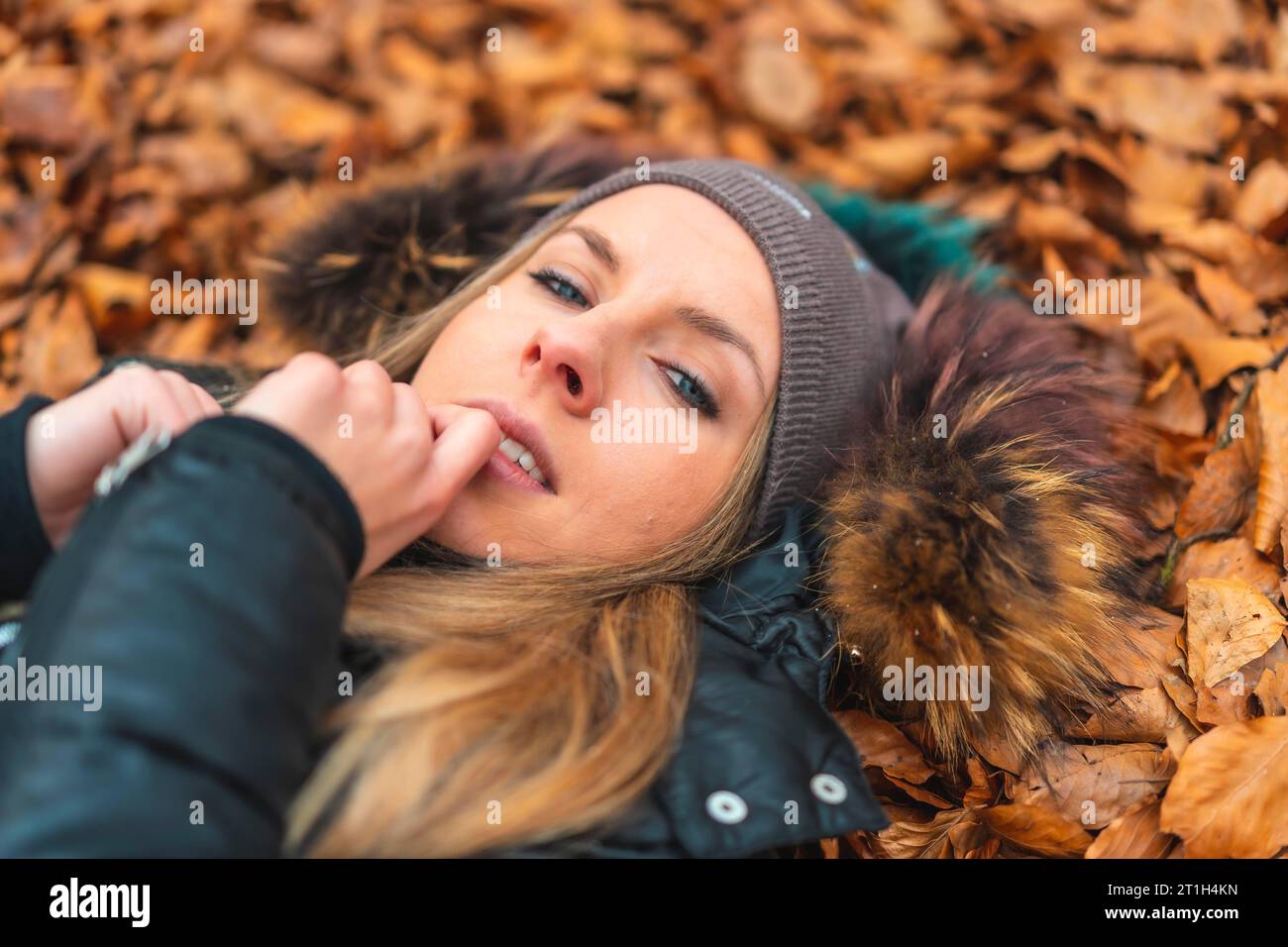 Lifestyle session, A beautiful young woman in the leaves of the ...