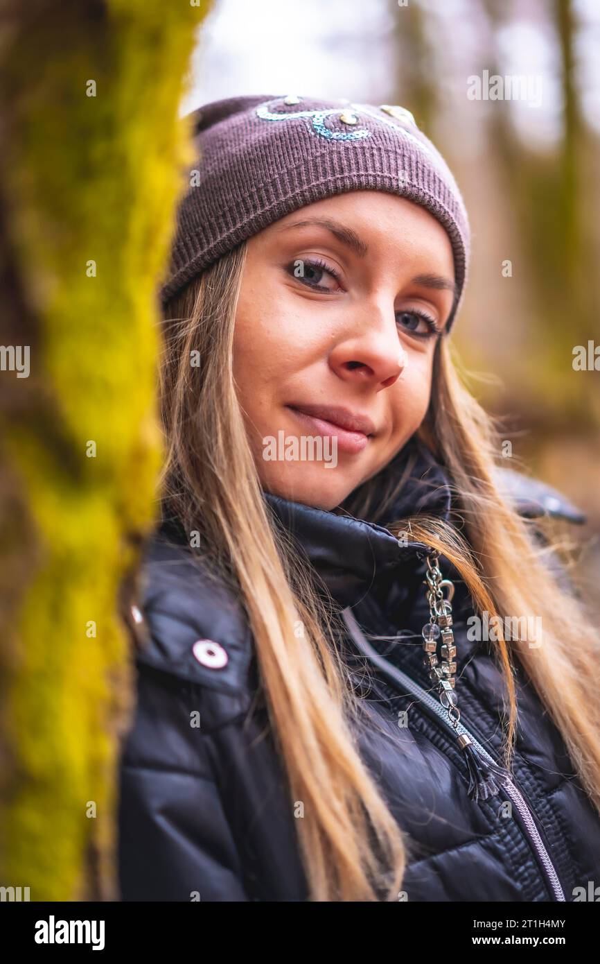 Portrait of a blonde girl in a forest with a hat in a cold winter Stock ...