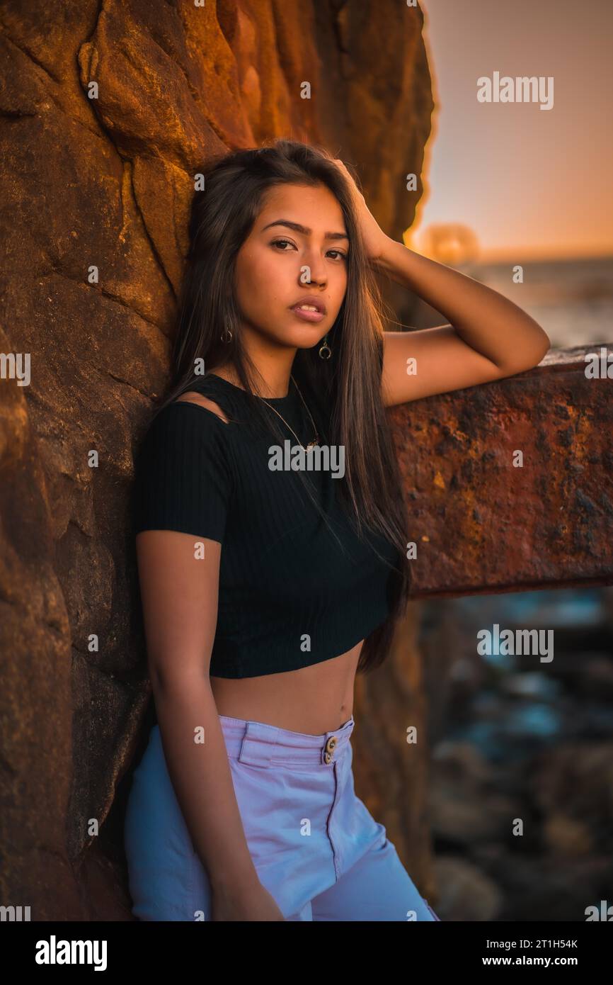 A young pretty brunette Latina with long straight hair in a short black ...