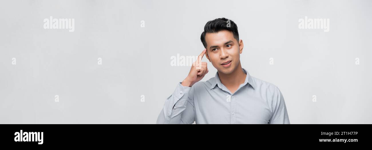 Young man point finger at his head gesture thinking portrait white ...