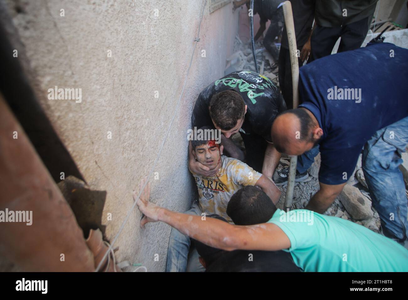 Wounded civilians are rescued by other civilians after the bombing of a ...