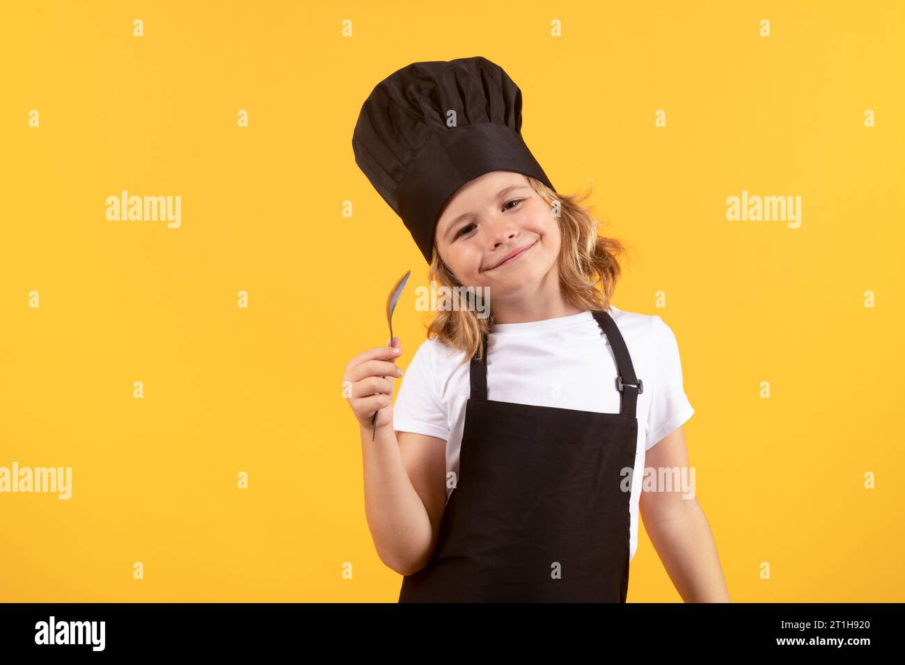 Cute kid boy cook with cooking spoon. Child chef cook prepares food on ...