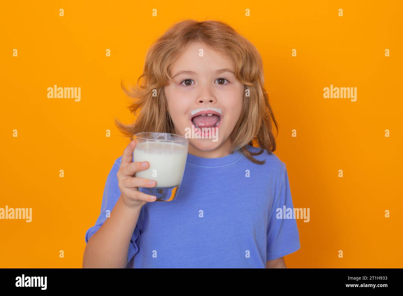 Dairy milk. Portrait of child drinking milk, yellow isolated studio ...