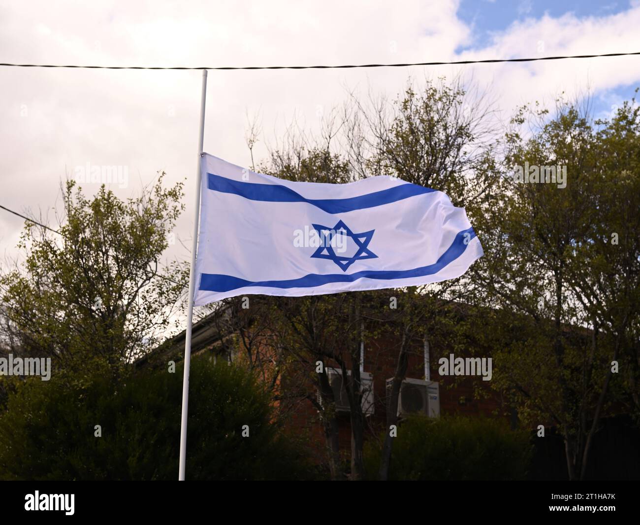 Israel flag fluttering in the wind at half-mast, or half-staff, outside ...