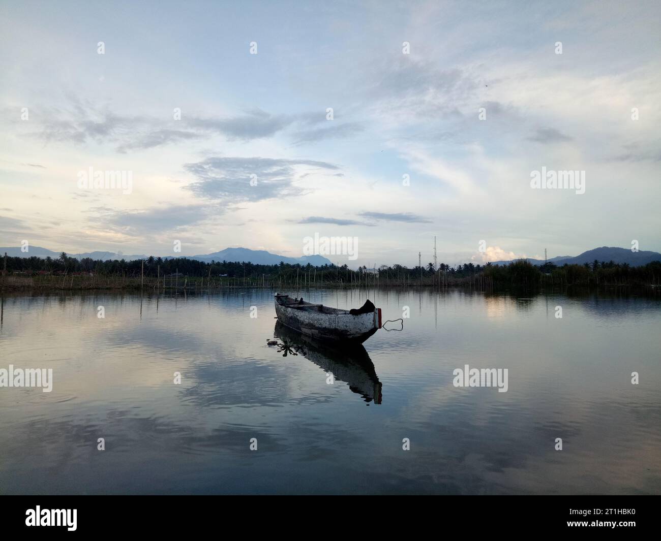 Traditional wooden boat floating on the waters of Lake Limboto ...