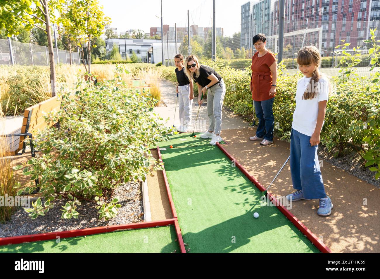 mini golf in nature. mini golf player putting golf ball into the hole ...