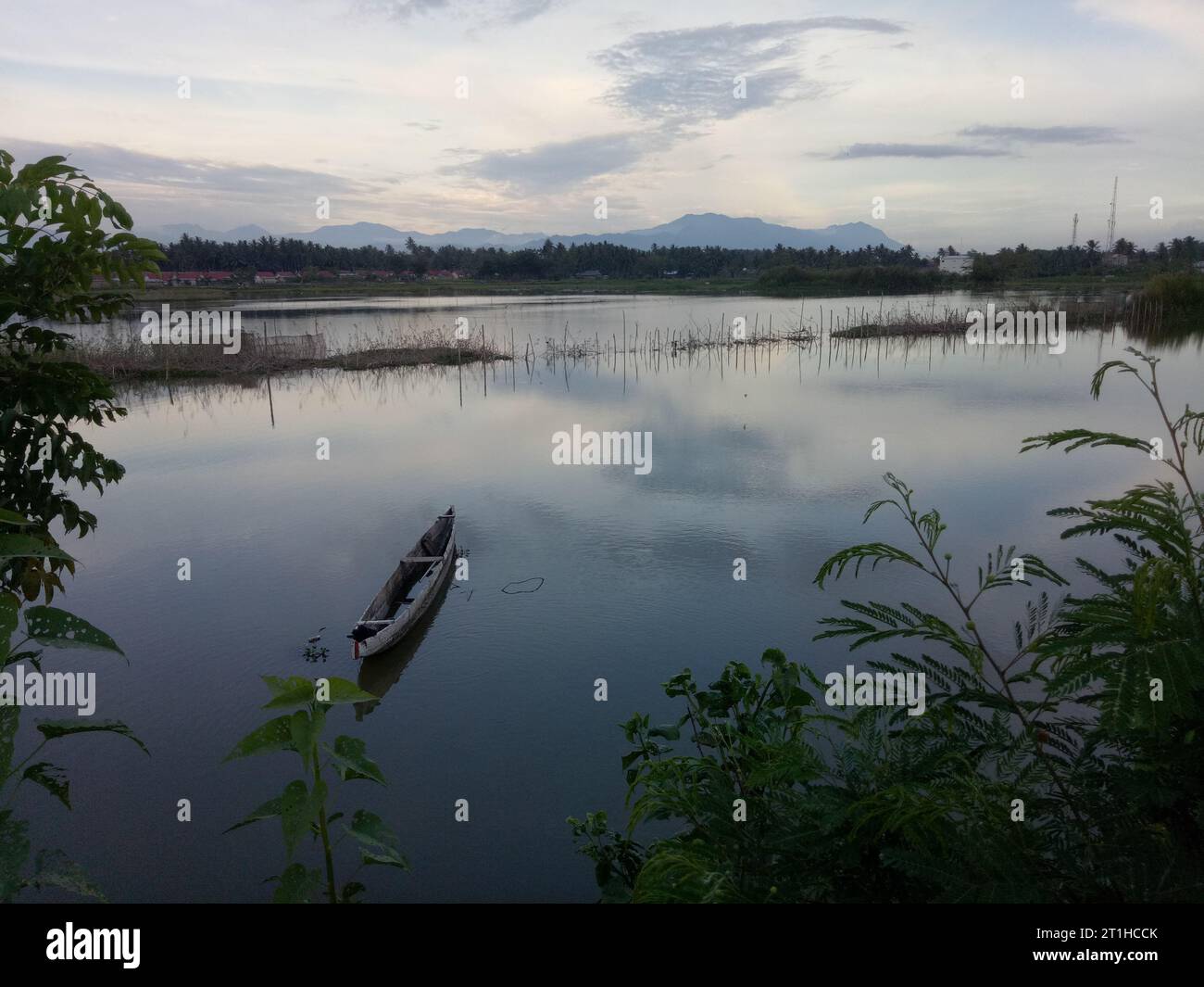 Traditional wooden boat floating on the waters of Lake Limboto ...