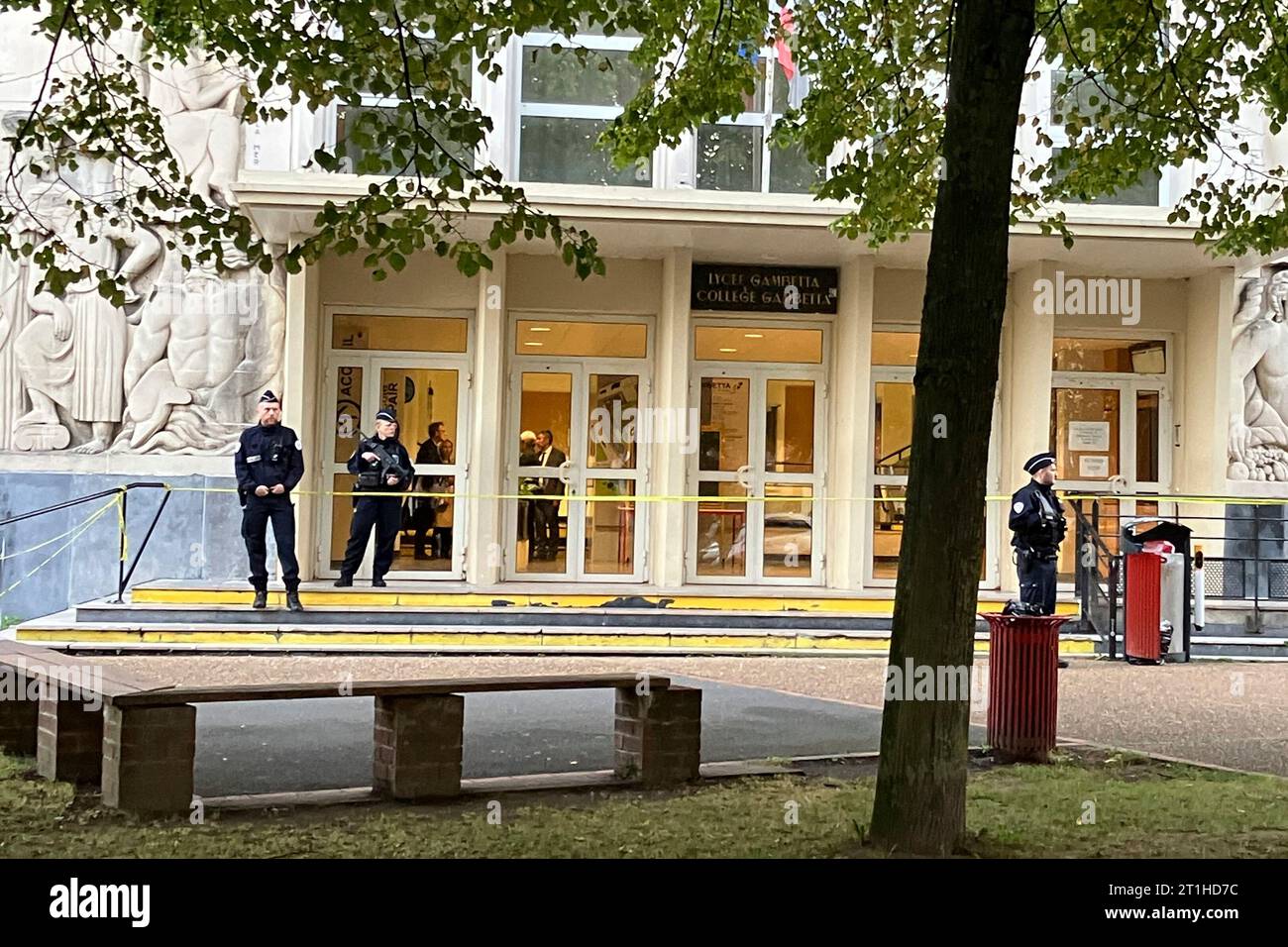 Police officers stand guard outside the high school where a man stabbed ...