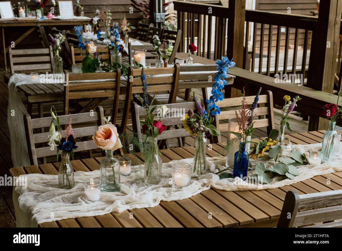 A rustic wooden dining table with multiple vases filled with fresh ...