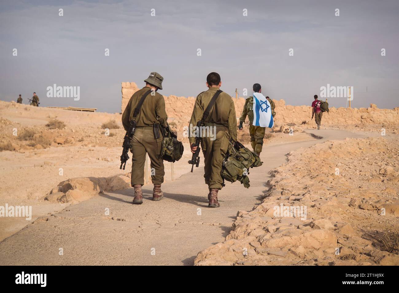 Back shot of several soldiers of israel army walking with an israel ...