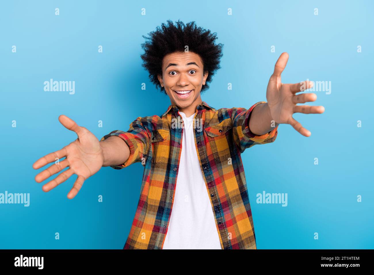 Portrait of impressed pleasant guy with perming coiffure dressed plaid ...