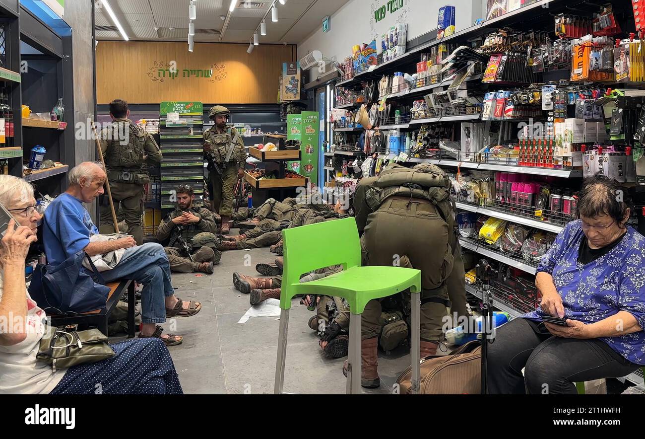 Israeli soldiers and civilians evacuated from Kibbutz Kfar Aza gather ...