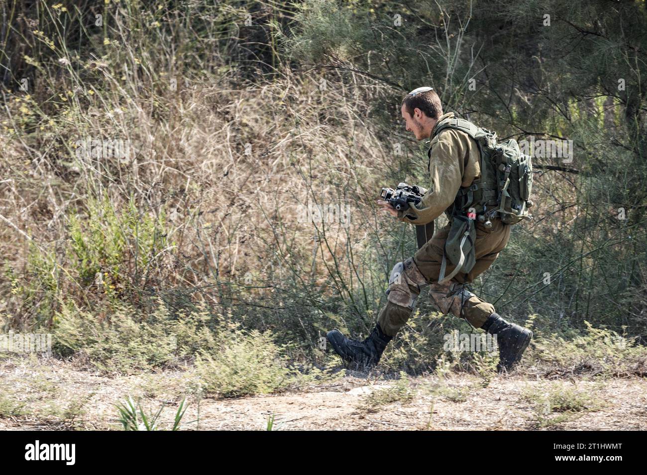 Zikim, Israel. 14th Oct, 2023. An Israeli soldier takes cover near the ...