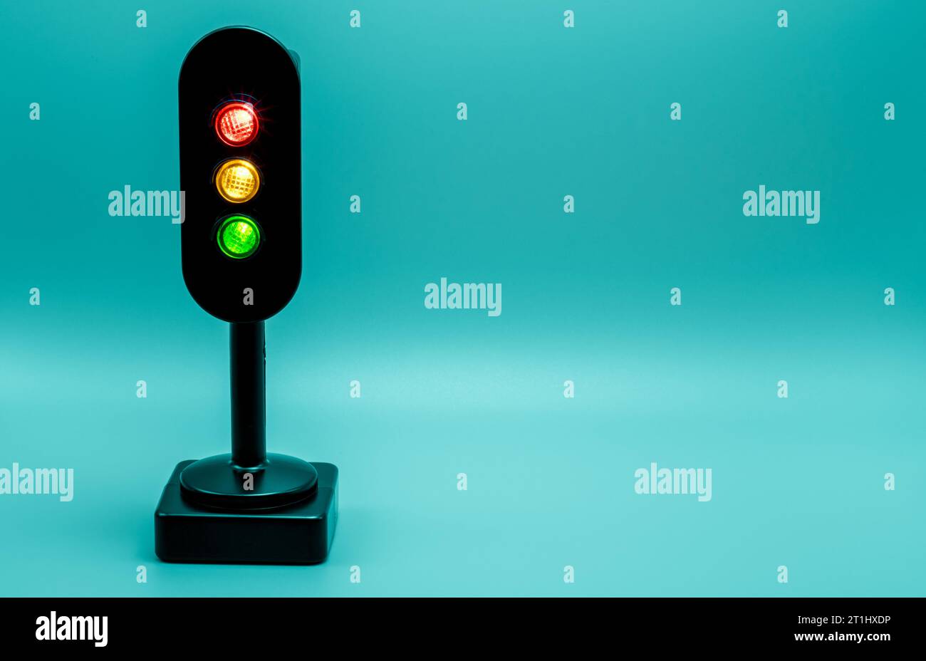 Miniature traffic light with red, orange and green light on. Studio ...