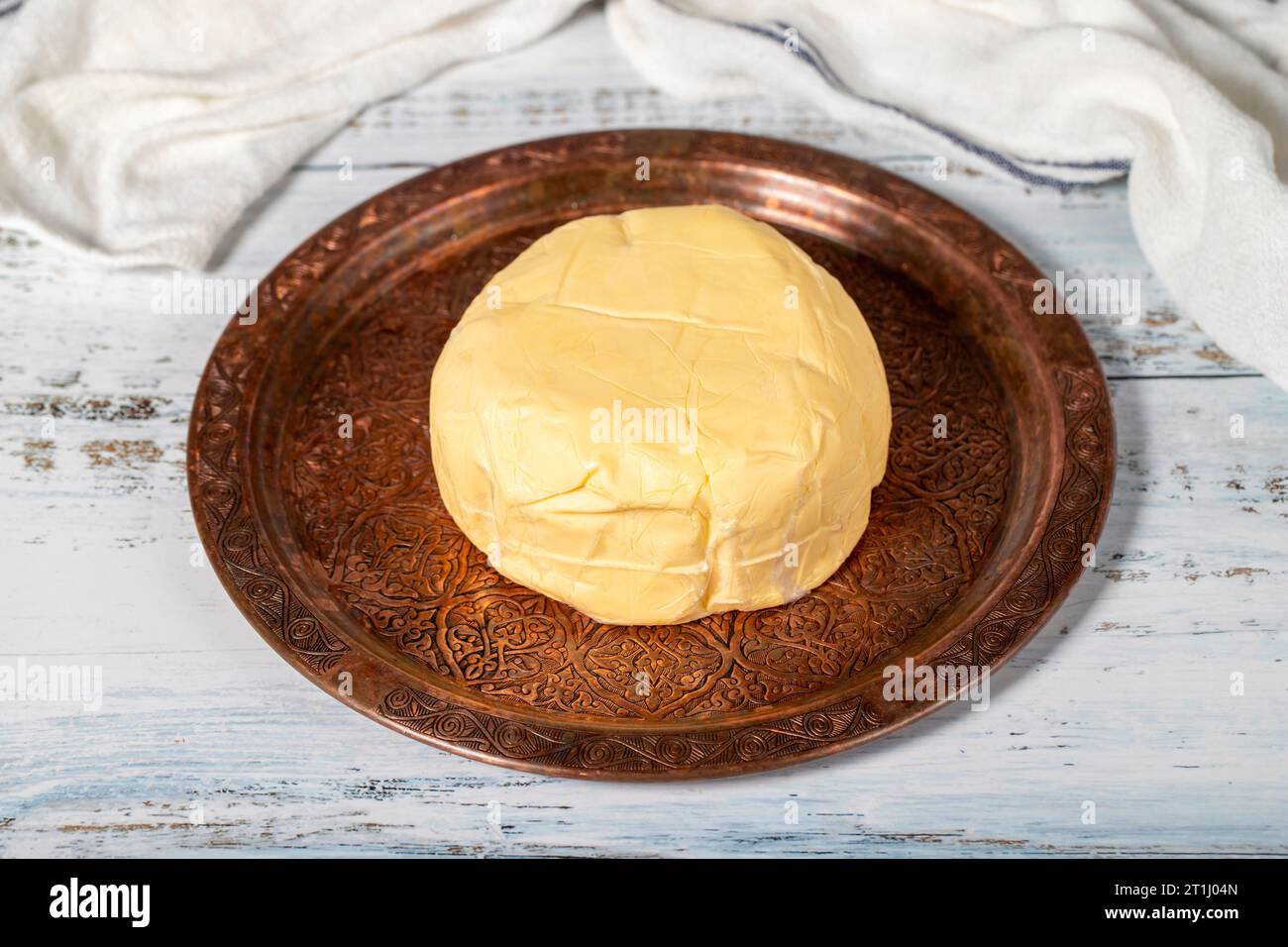 Butter in a copper plate. Organic fresh cow butter on wood background ...