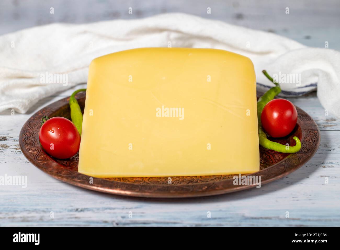 Aged cheese on a copper plate. Organic fresh cow cheddar on wood ...