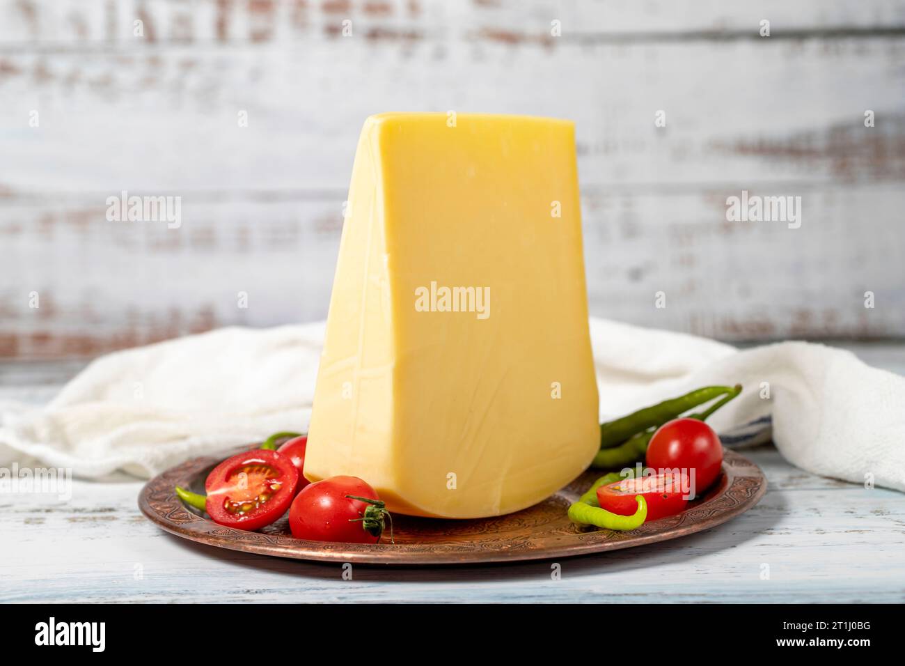 Aged cheese on a copper plate. Organic fresh cow cheddar on wood ...