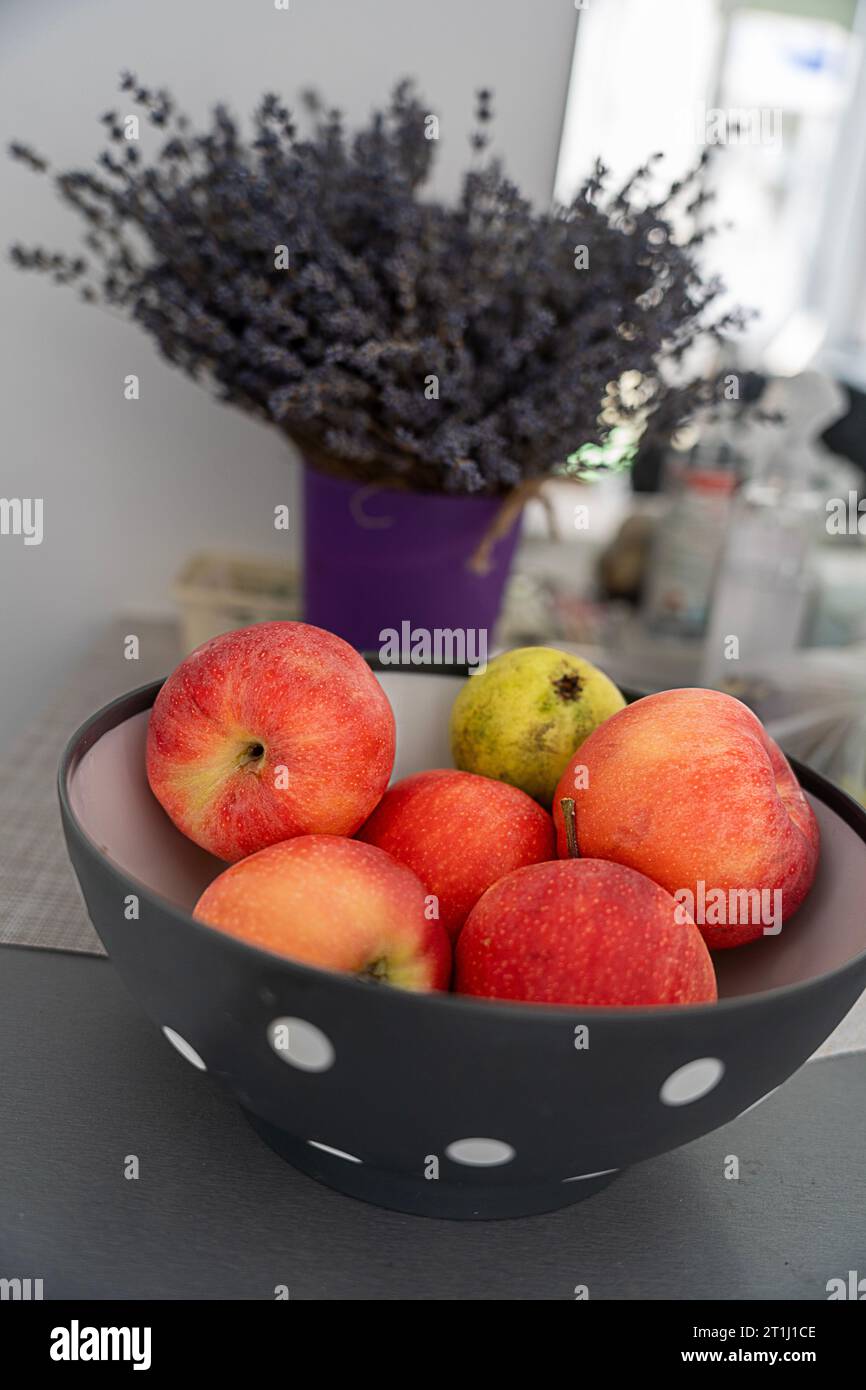 Red apples in a ceramic plate, on a background of lavender, composition ...