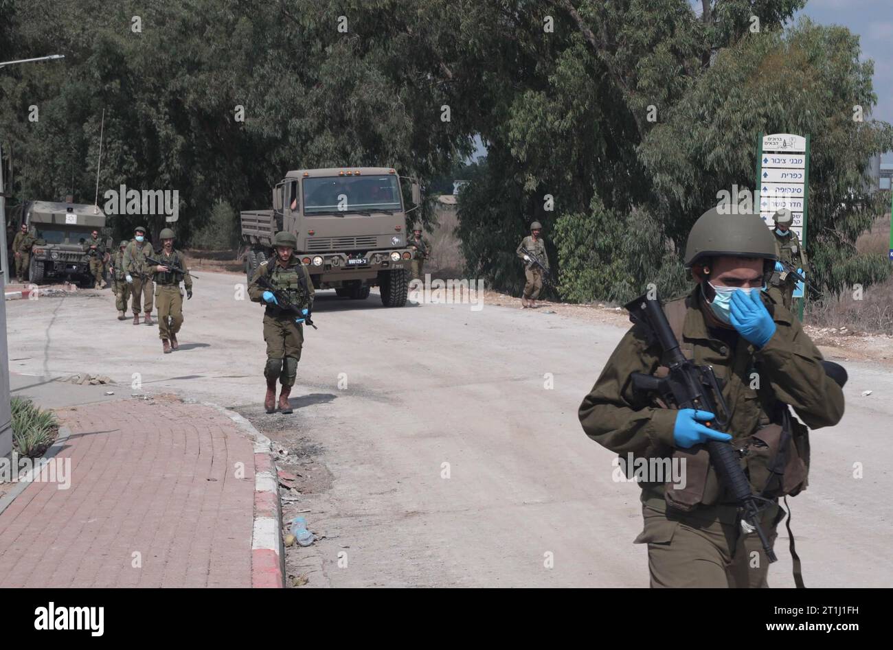 Israeli soldiers walk out Kibbutz Kfar Aza where Hamas militants killed ...
