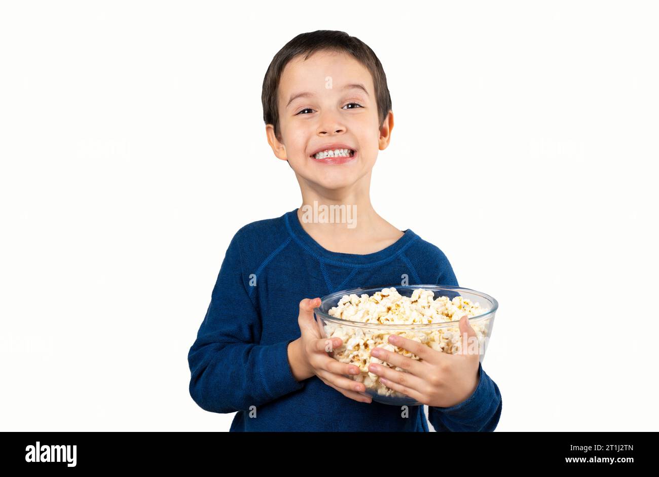 Dark haired little child eating popcorn snack isolated white background ...
