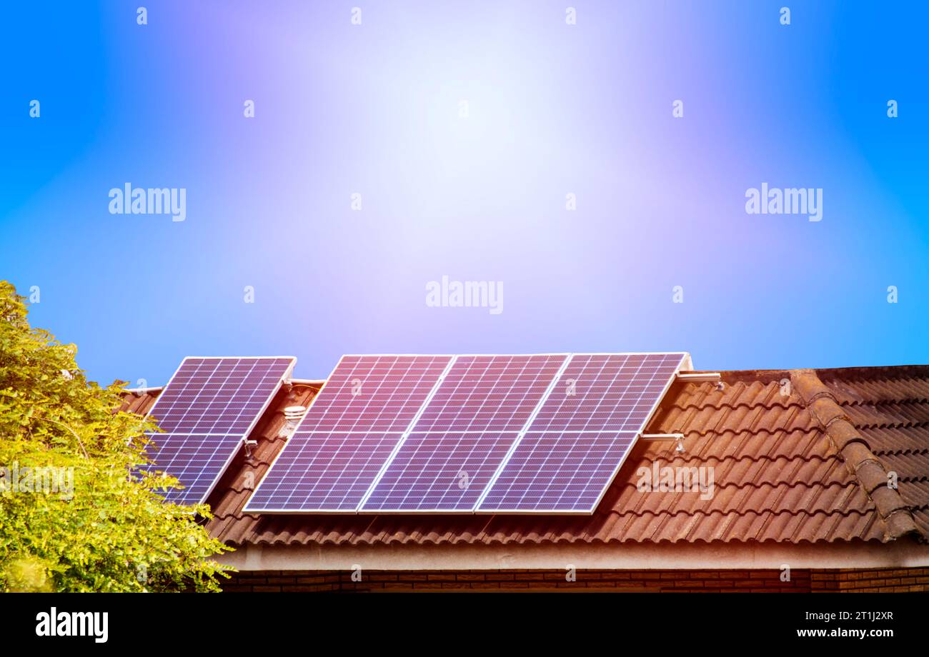 Solar panels on the tiled roof of the house in the sun. Electricity ...