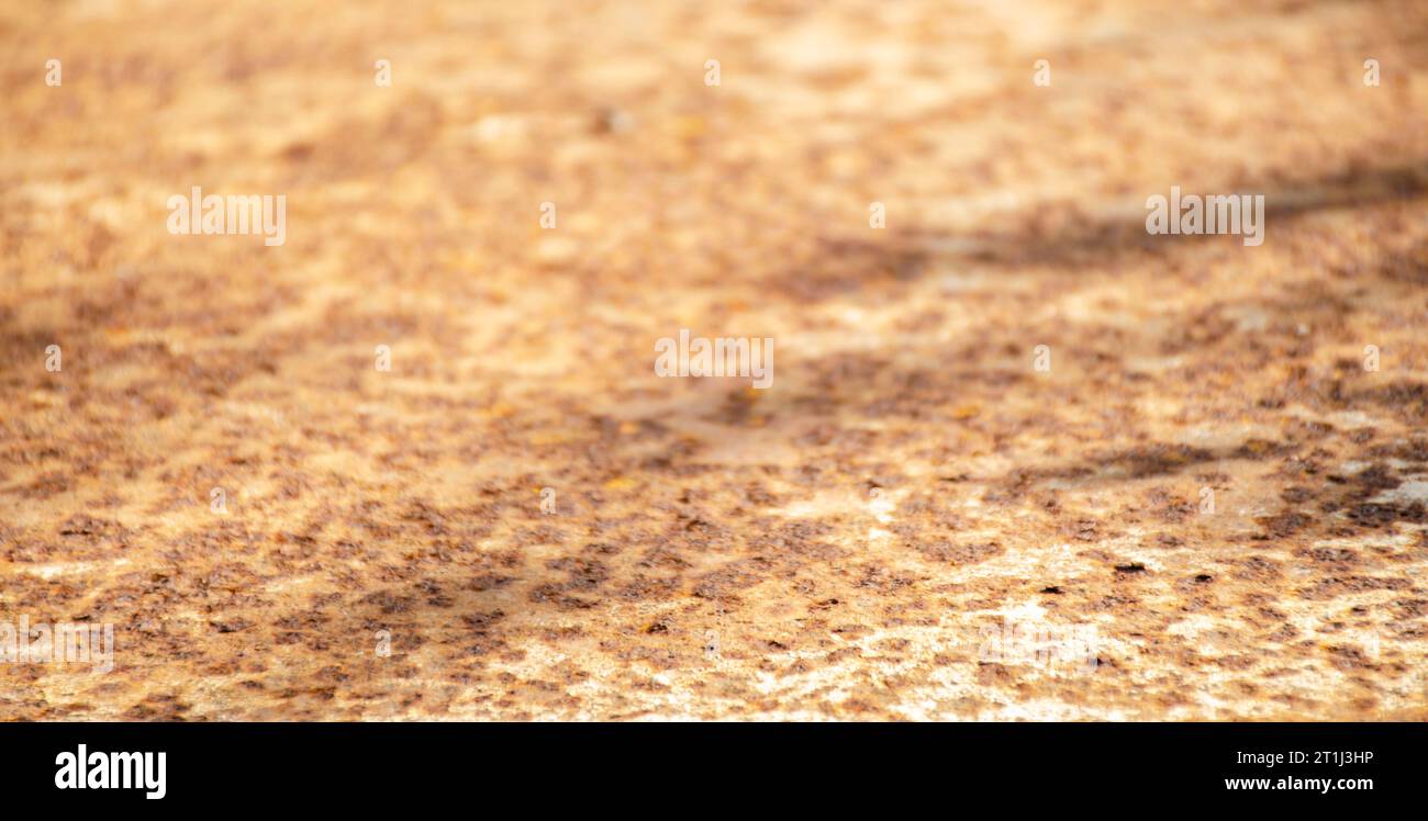 Orange rust stains on weathered steel plate. Yellow iron table and old ...