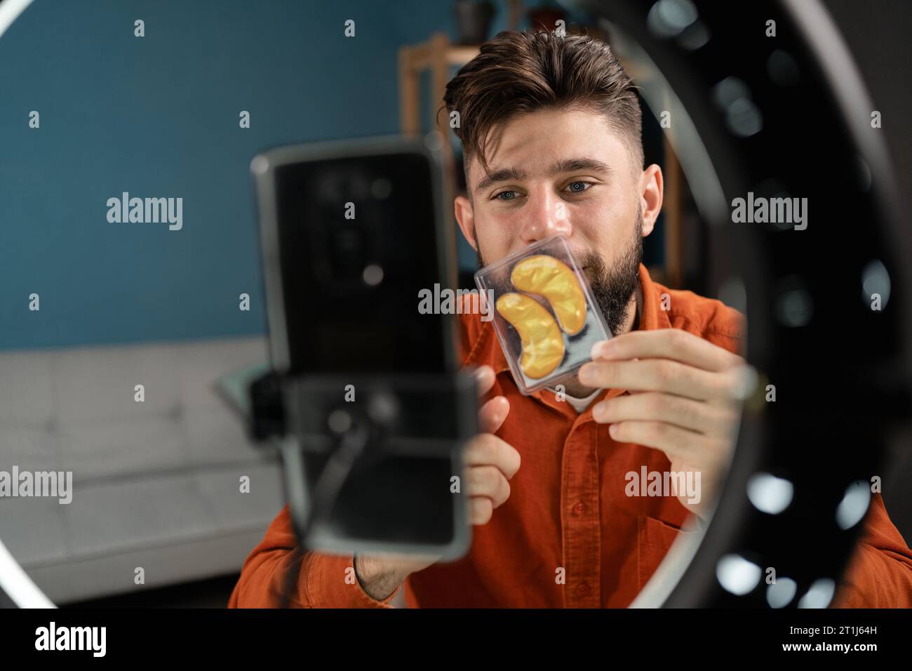 Beautician man recording tutorial on mobile phone at home. Male showing ...