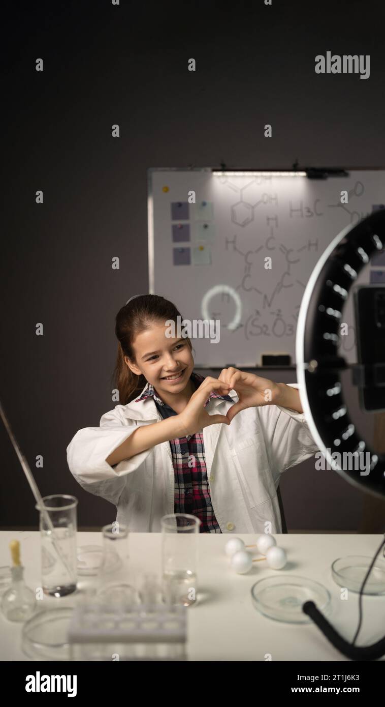 Teen Girl blogger researcher learning in experiment with test tubes in ...