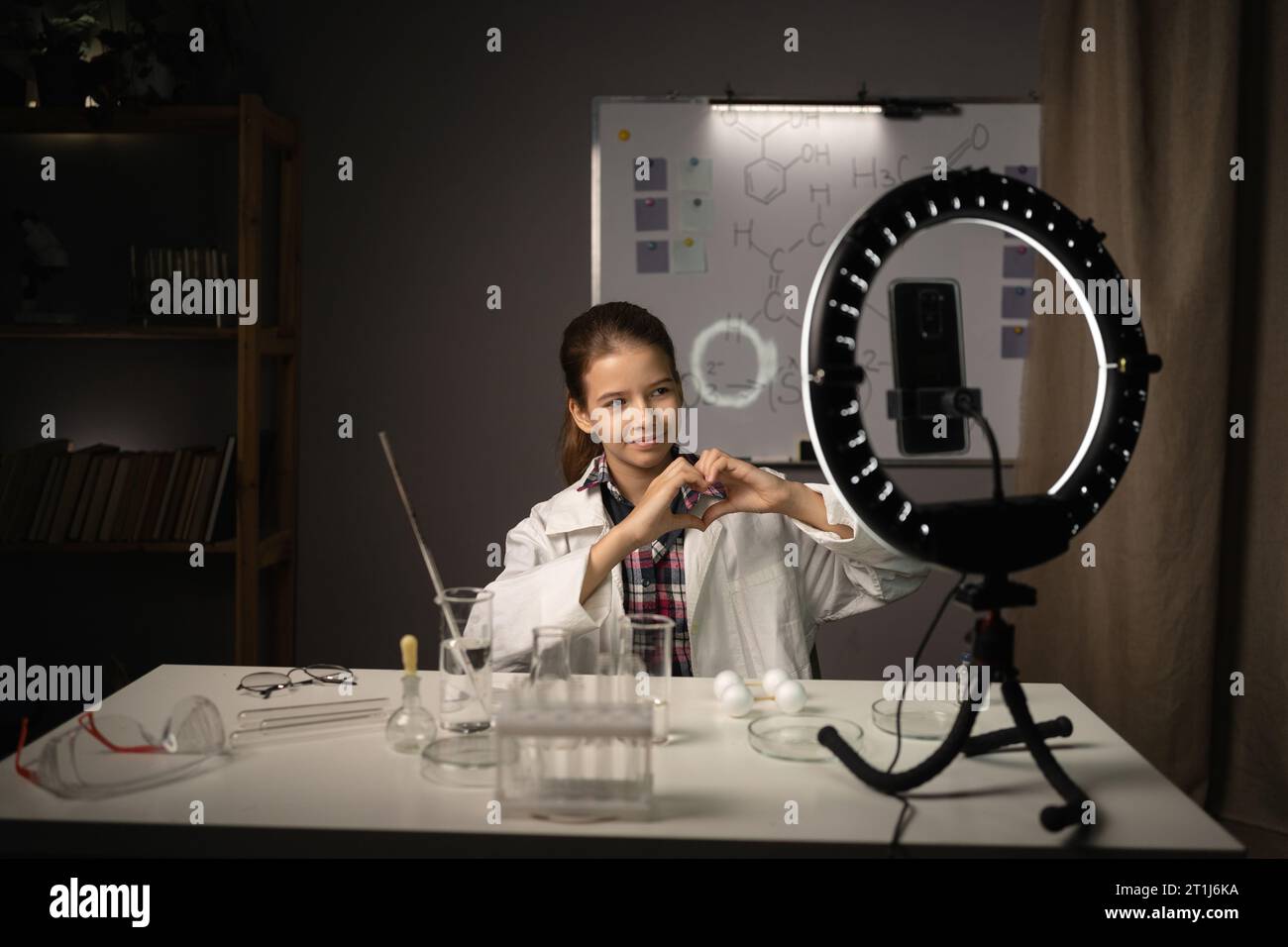 Teen Girl blogger researcher learning in experiment with test tubes in ...