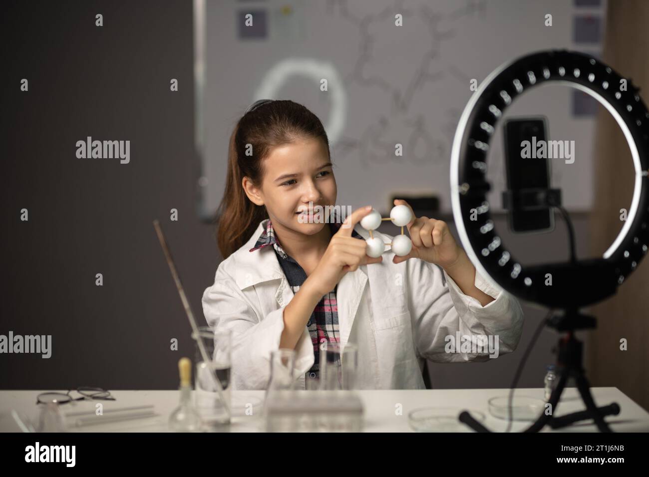 Science student recording learning blog holds model of molecular ...