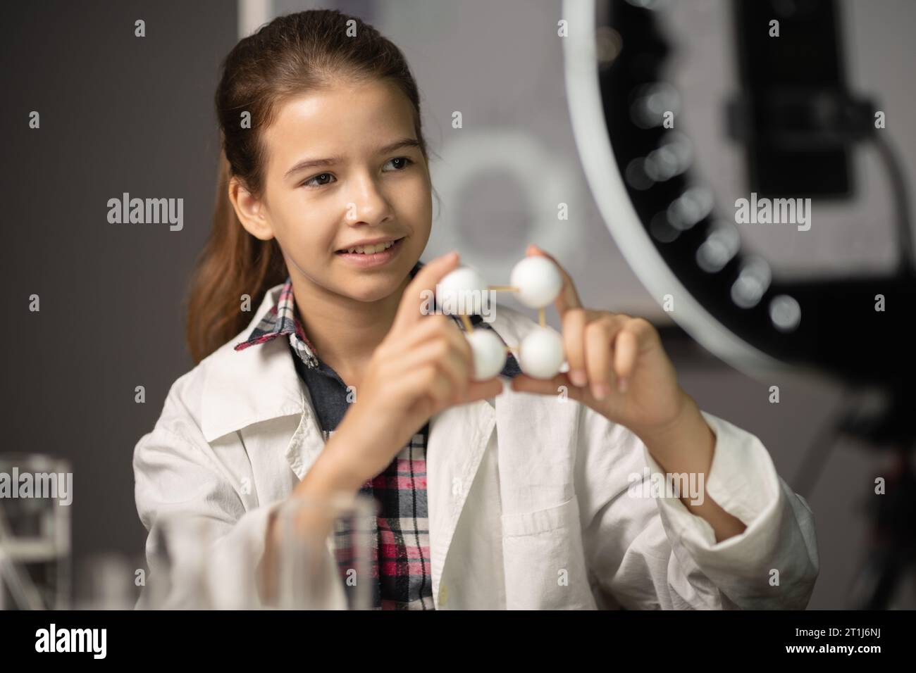 Back to school. Science student recording chemistry blog holds model of ...