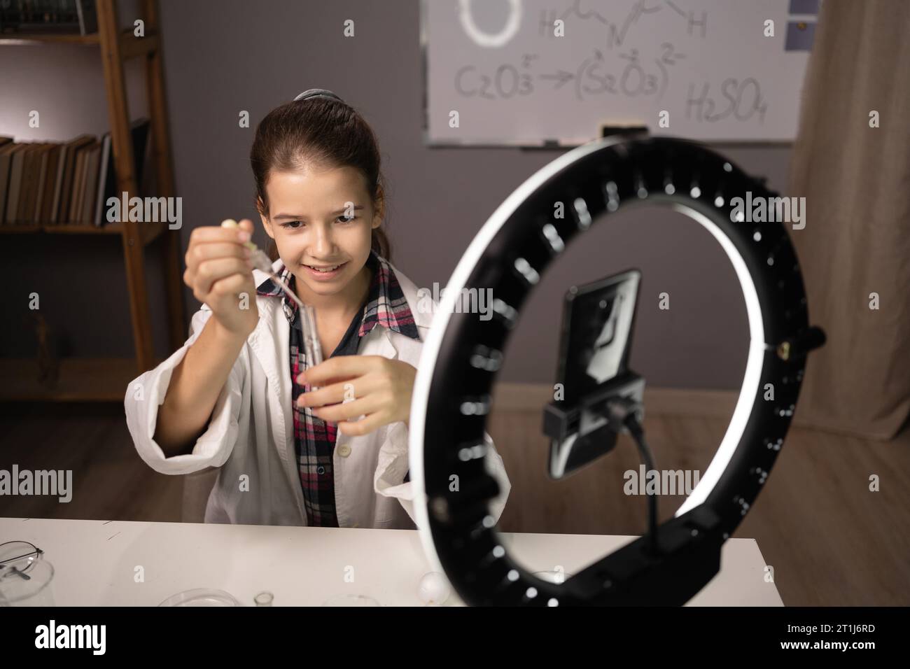 School girl blogger making chemistry experiments and recording video ...