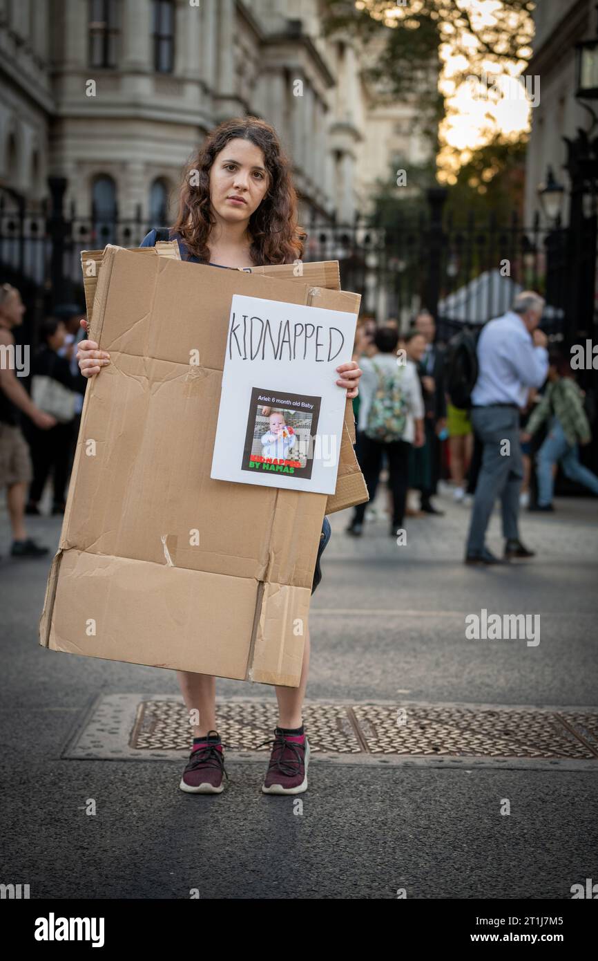 A girl holds a placard of the atrocities caused by Hamas when they ...