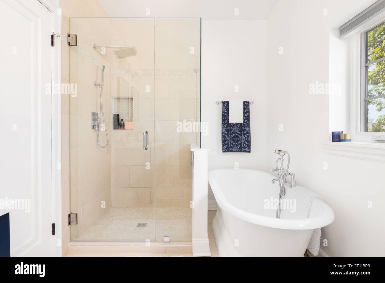 A bathroom's walk-in shower with brown tiles and a free standing ...