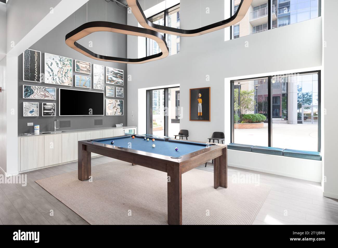 A modern billiards room with a pool table with a blue top, a modern ...