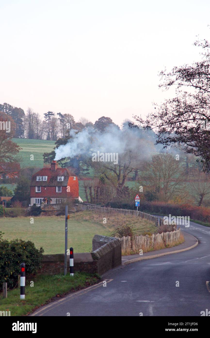 A house in the British countryside heated by burning wood as smoke ...