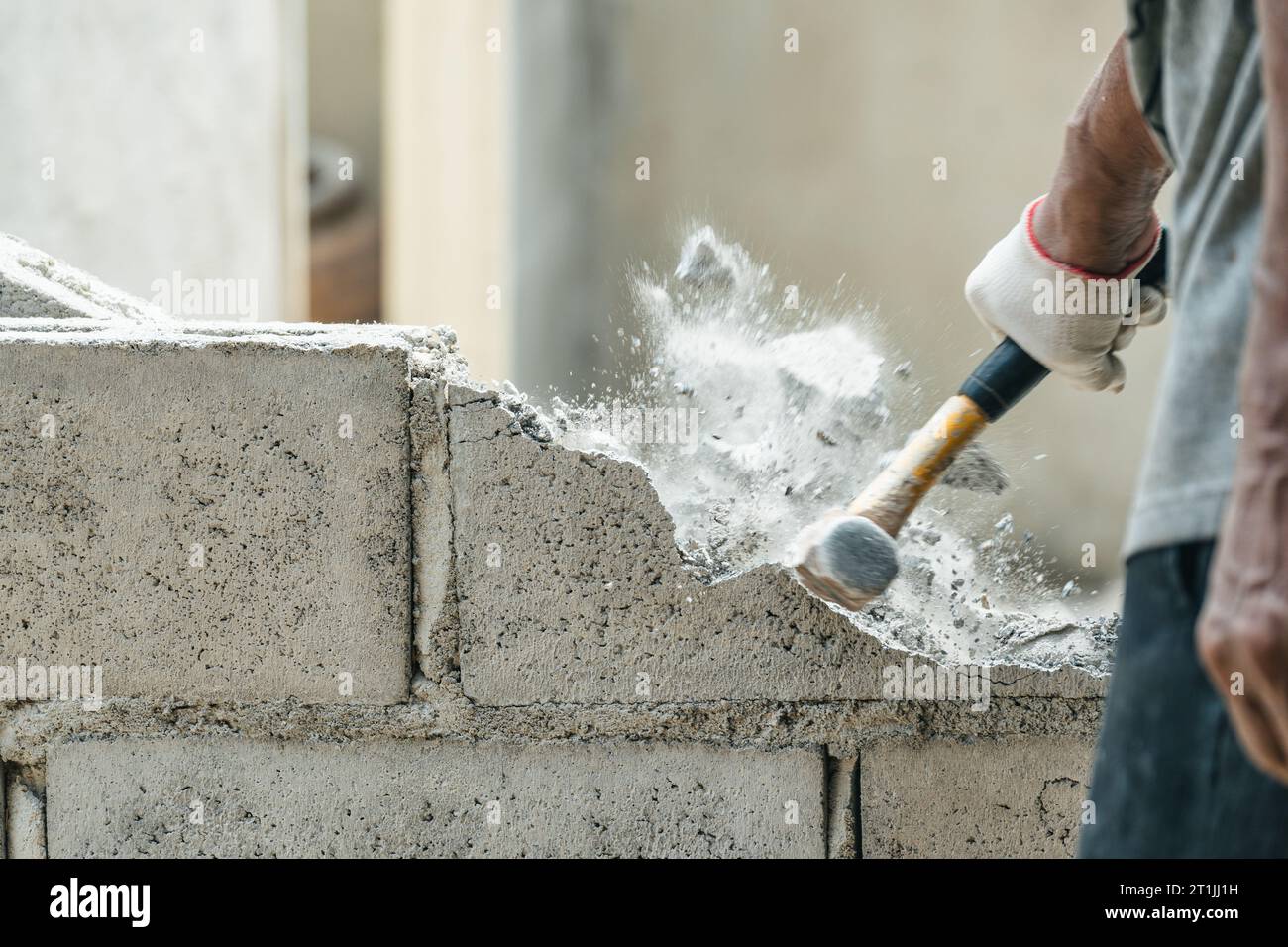 Hand of worker using hammer smashing and demolish on brick block wall ...