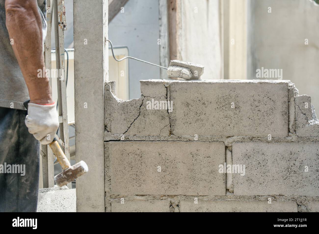 Hand of worker using hammer smashing and demolish on brick block wall ...