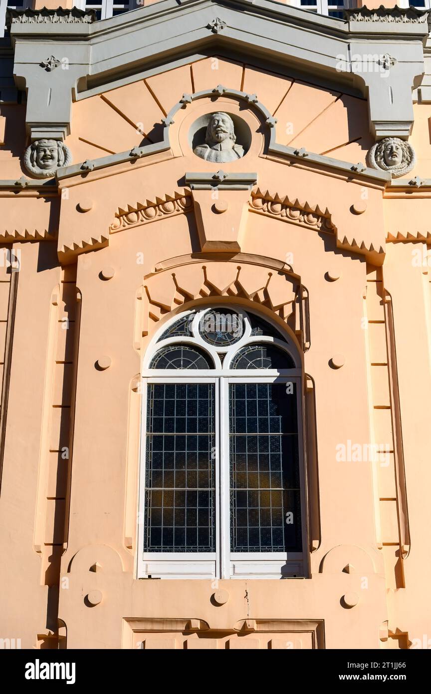 Vertial view of a window with a decorative statue on top. Architectural ...