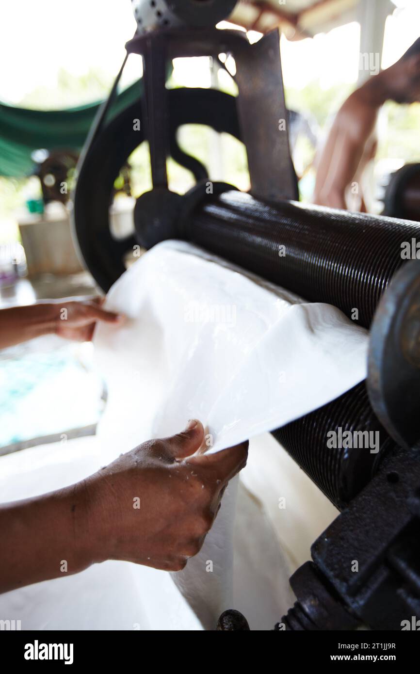 Rubber, industry and hands of person with roller in workshop, factory ...