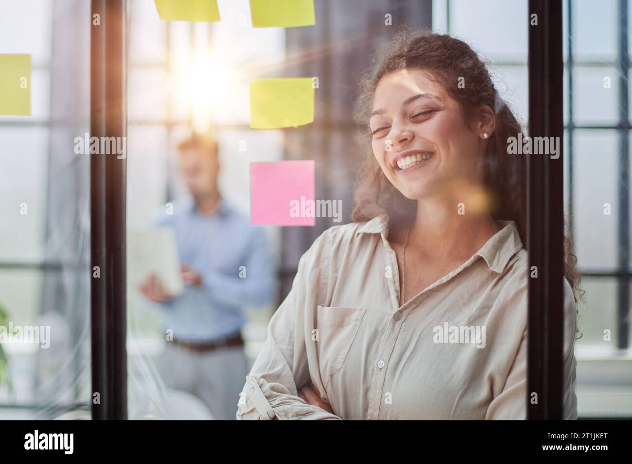 Smiling business woman looking out the window Stock Photo - Alamy