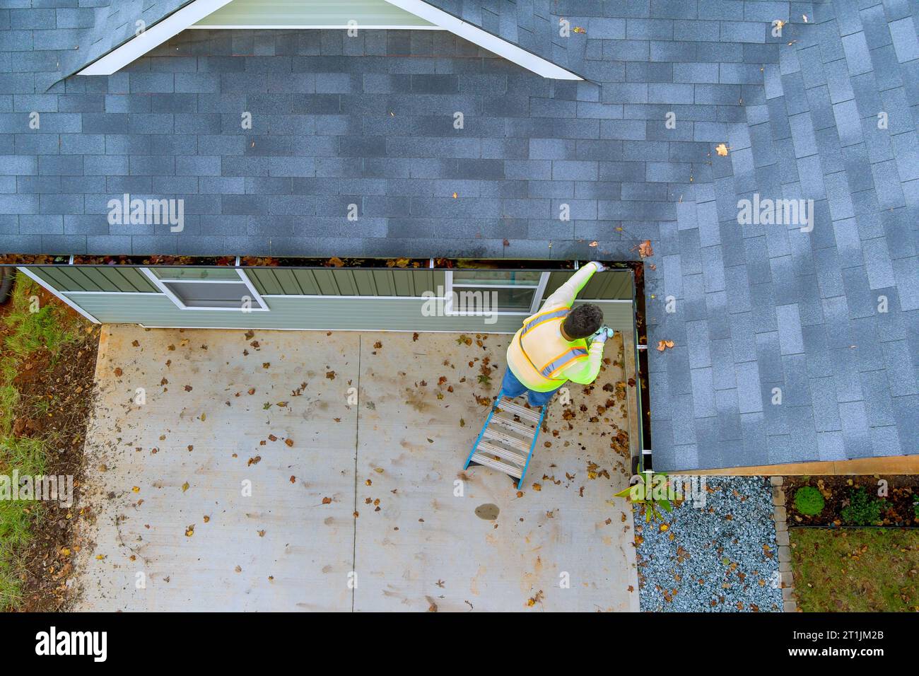 An employee is cleaning clogged roof gutter drain with dirt, debris ...