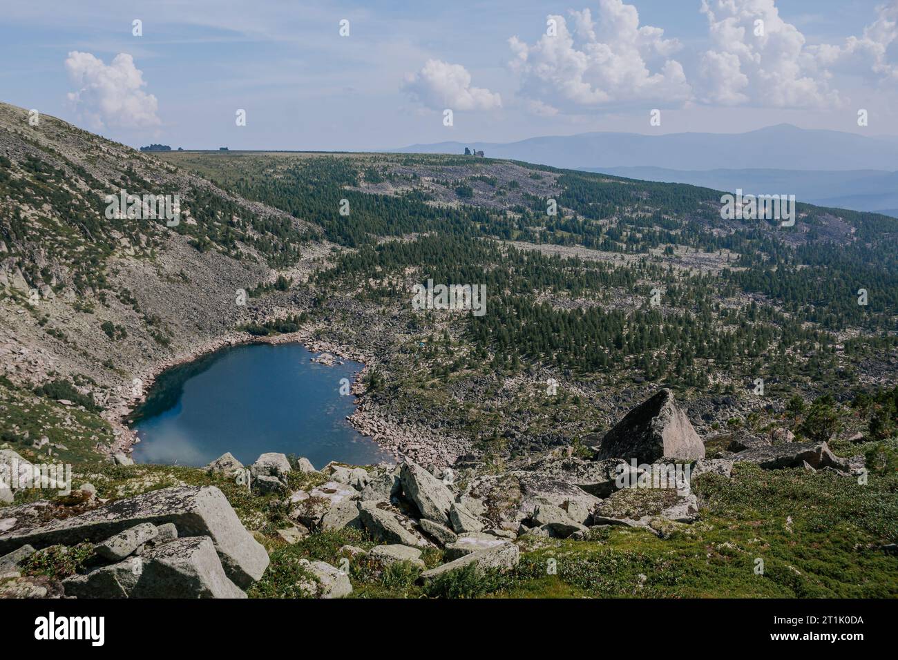 Summer day in low mountains. Stone hillsides, evergreen conifers, rocks ...