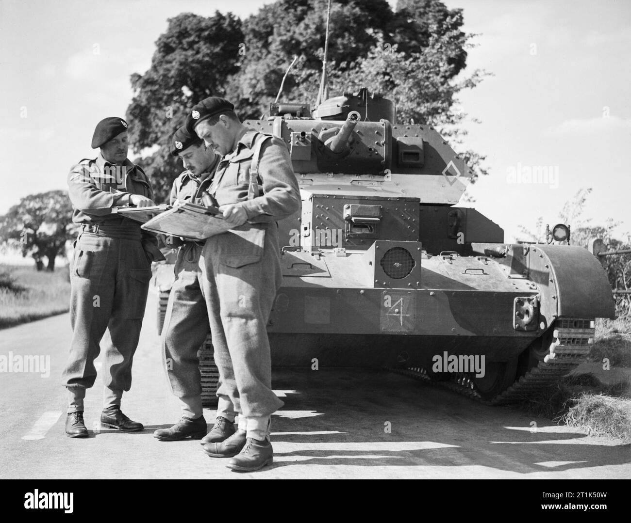 Royal Tank Regiment officers confer in front of a Cruiser Mk IVA tank ...