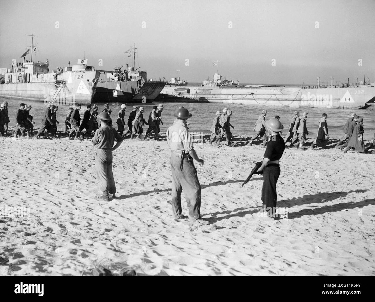 Italian POWs march to waiting landing craft during the Allied invasion ...