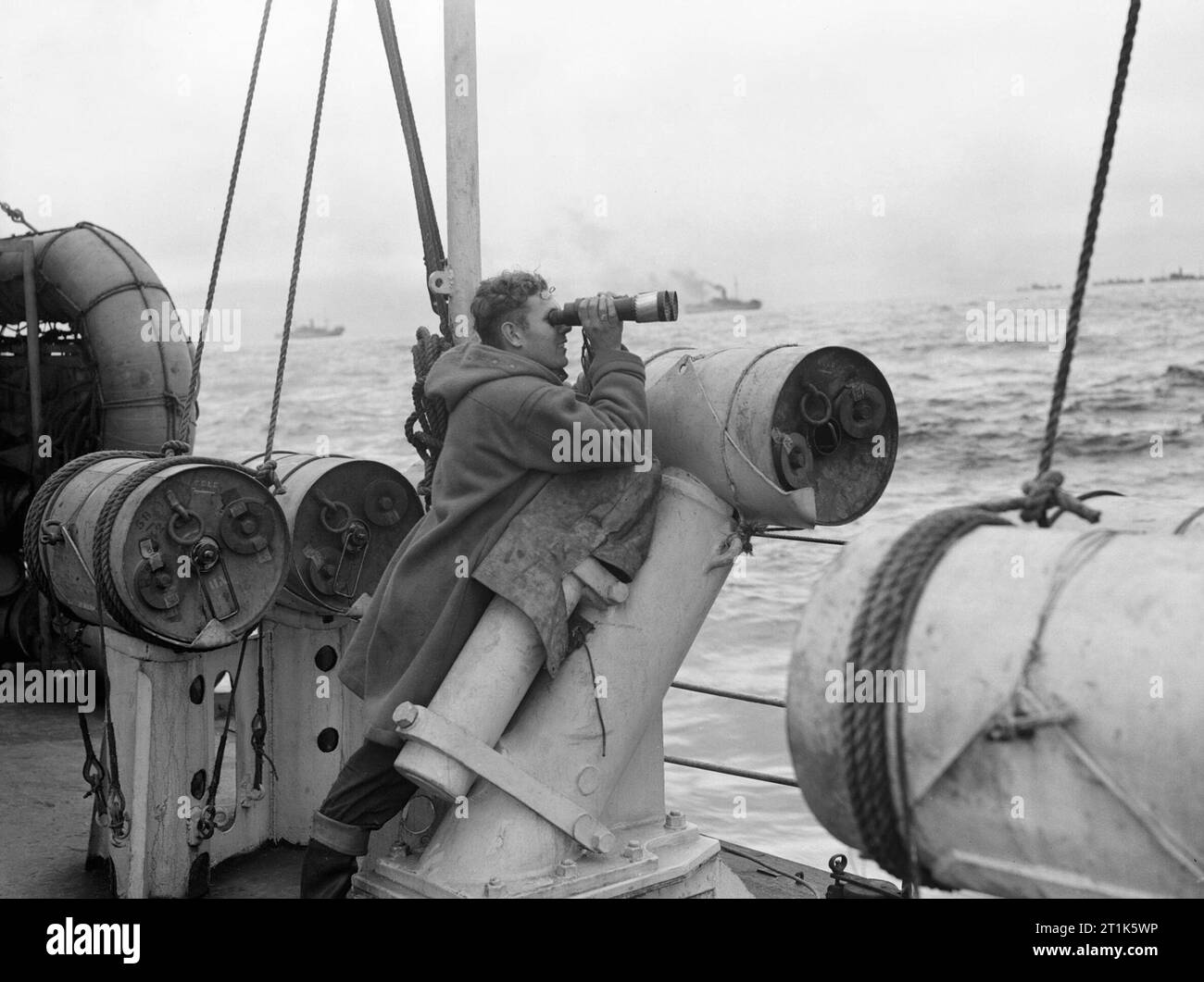 Leaning against a depth charge thrower, the quarterdeck lookout on ...