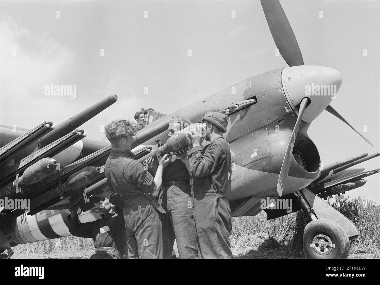 Ground crews loading 3-inch rocket projectiles onto a Hawker Typhoon Mk ...