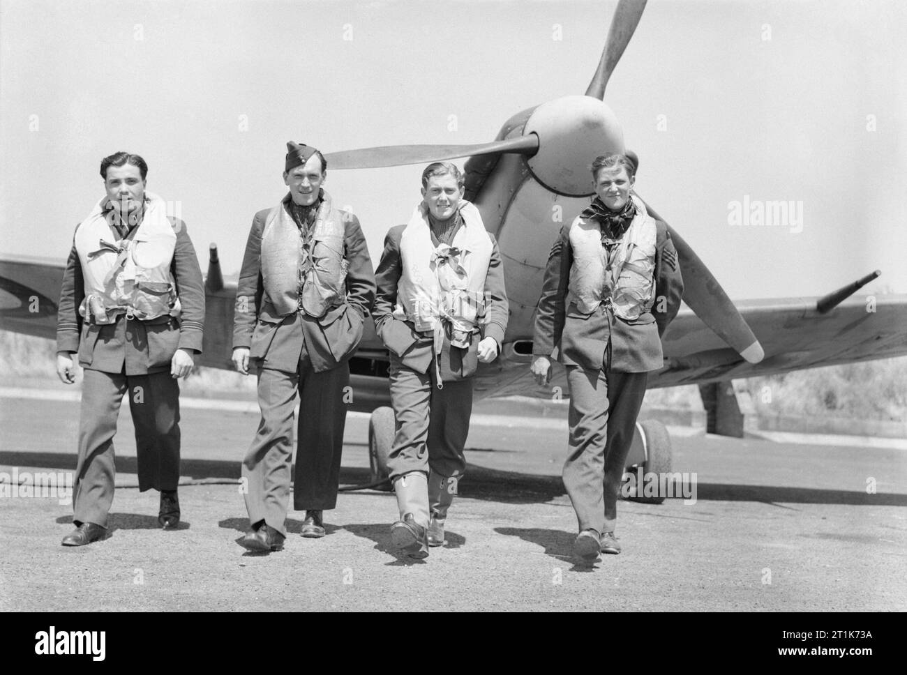 Pilots of No. 611 Squadron walk away from a Supermarine Spitfire Mk V ...