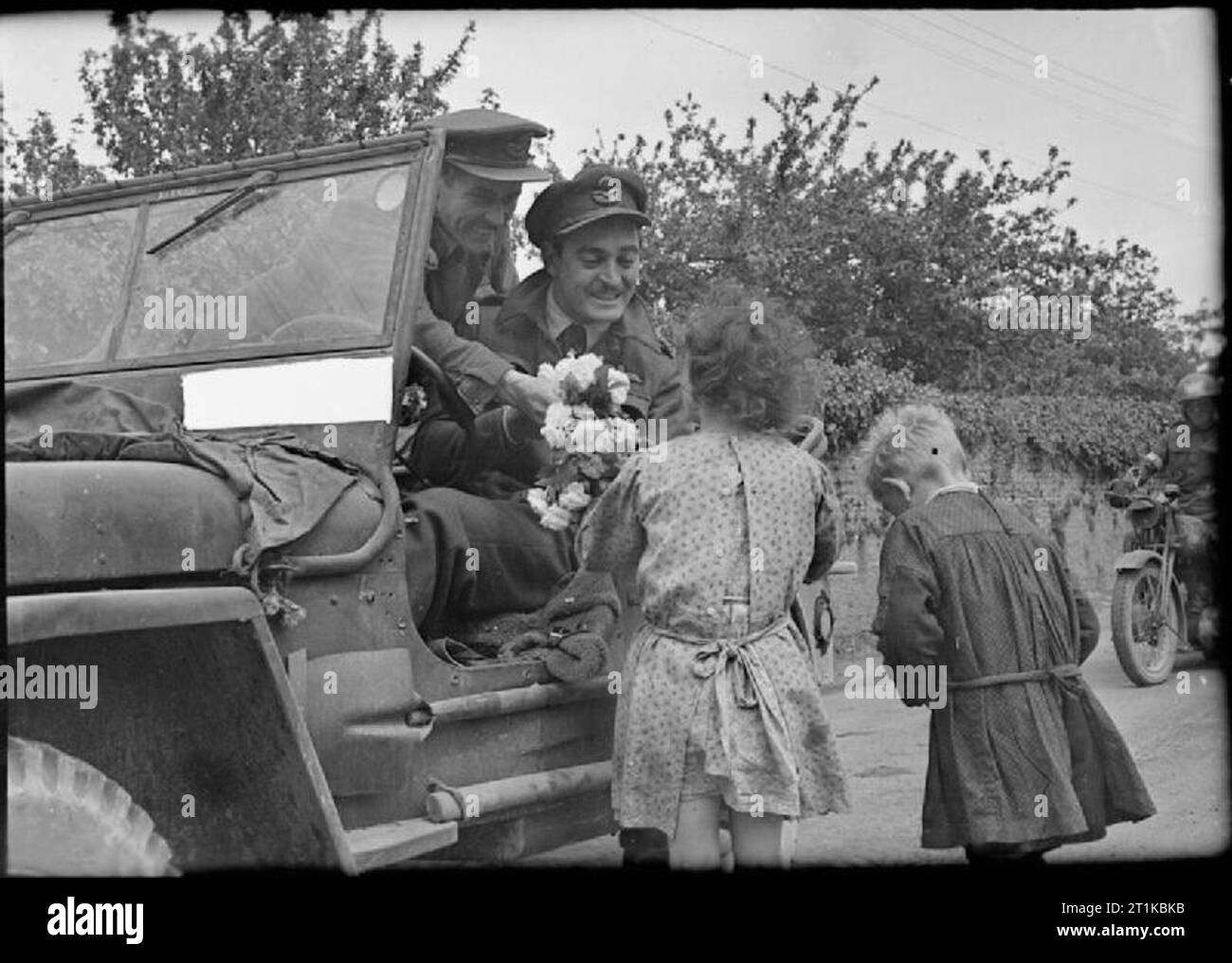 Royal Air Force- 2nd Tactical Air Force, 1943-1945. Two RAFofficers in a jeep receive flowers ...