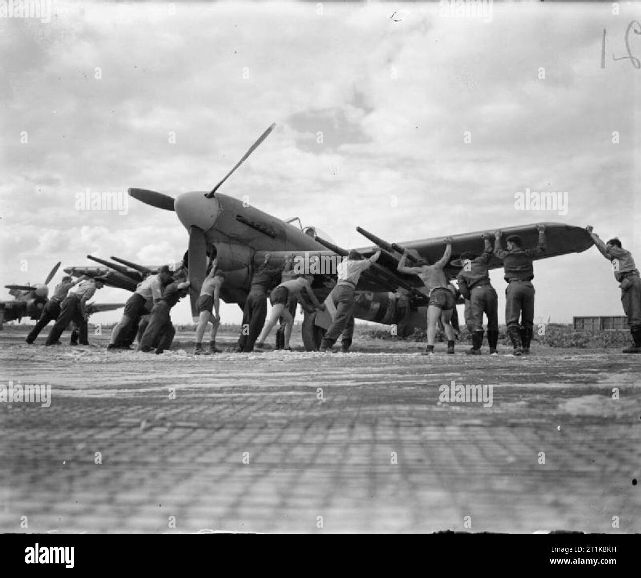 Royal Air Force- 2nd Tactical Air Force, 1943-1945. Pilots join ground crews in moving a Hawker ...
